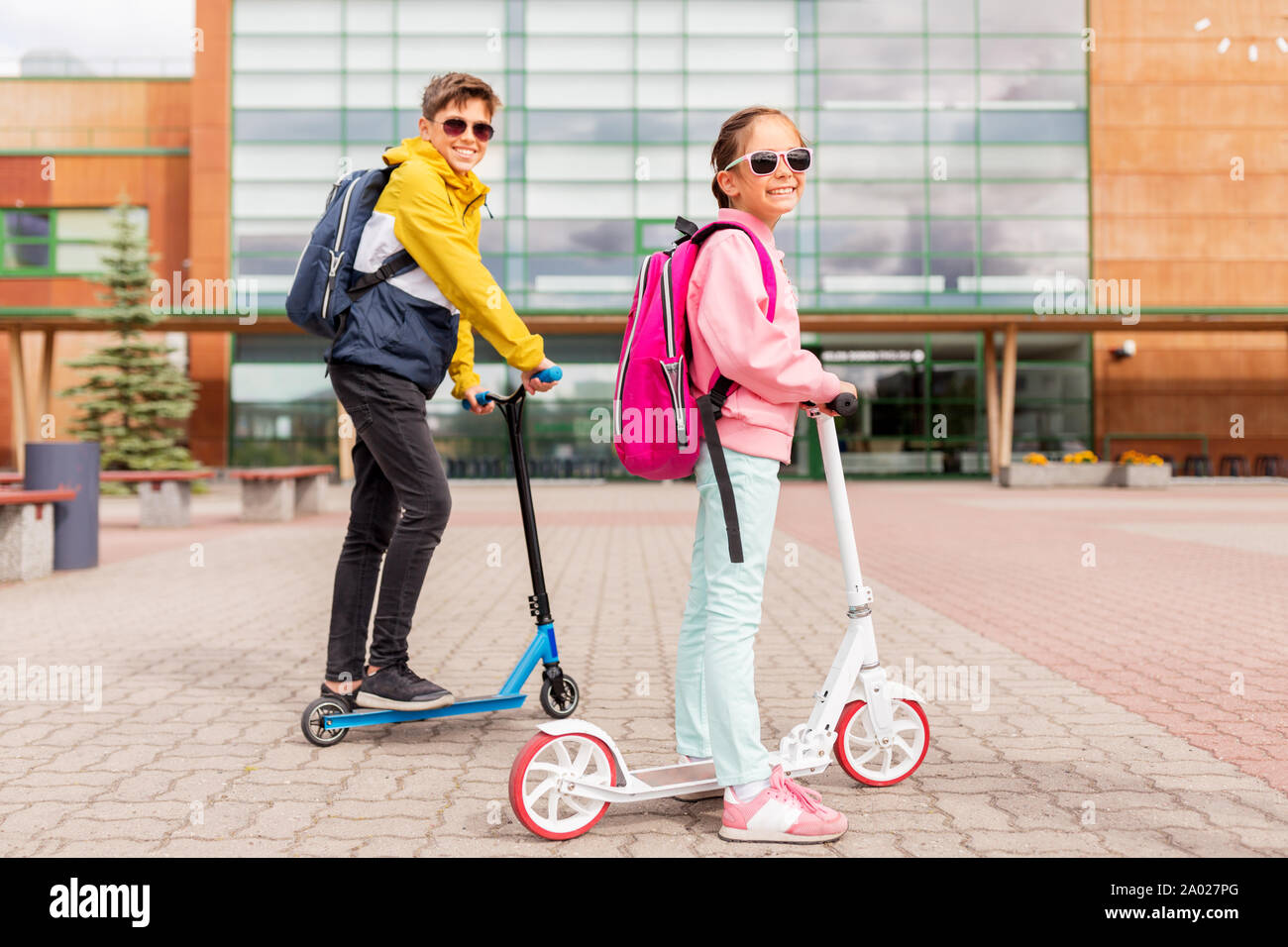 school children with backpacks riding scooters Stock Photo - Alamy