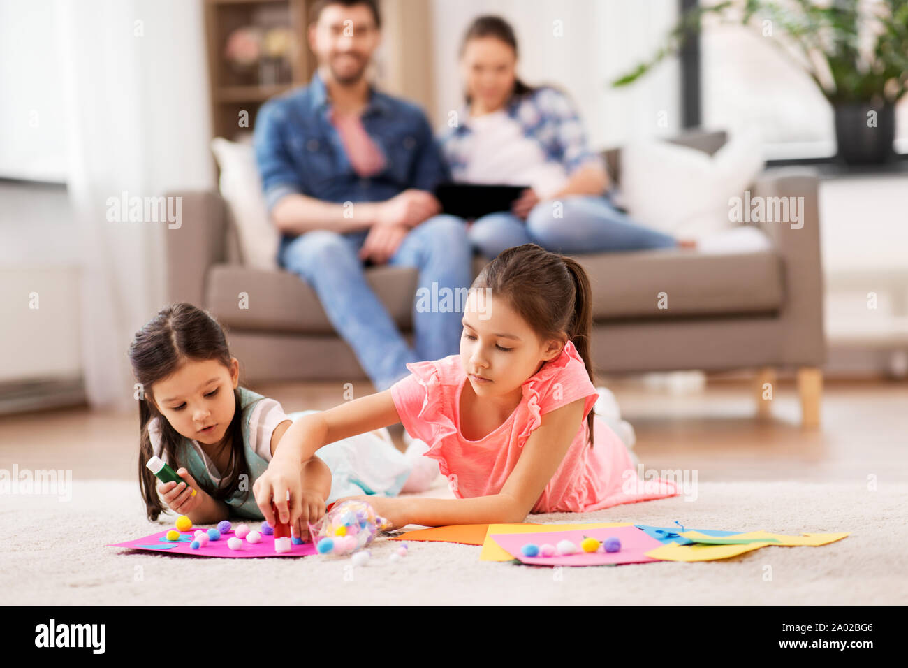 happy sisters doing arts and crafts at home Stock Photo - Alamy