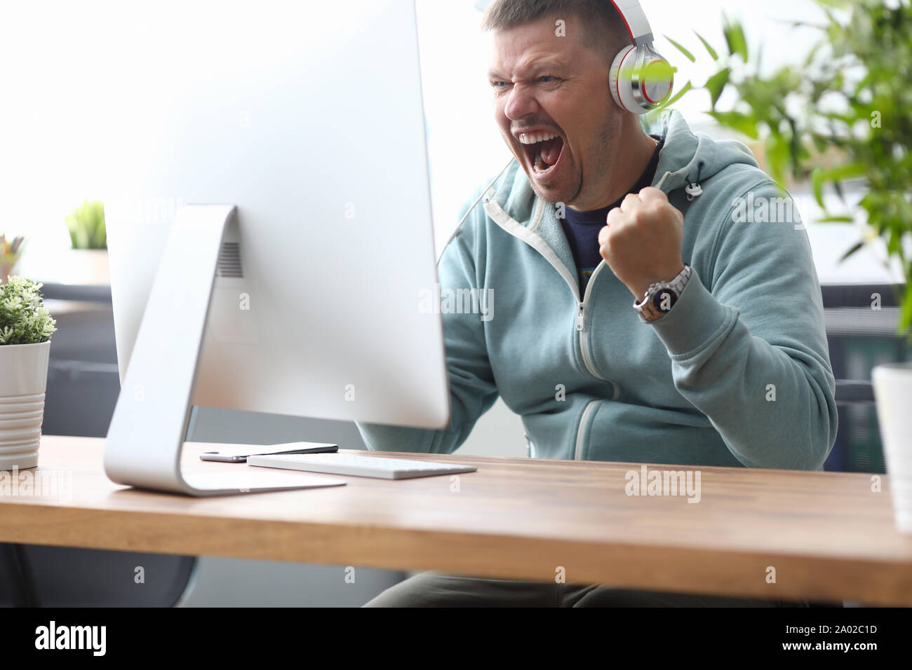 Man screaming in computer monitor sitting Stock Photo - Alamy