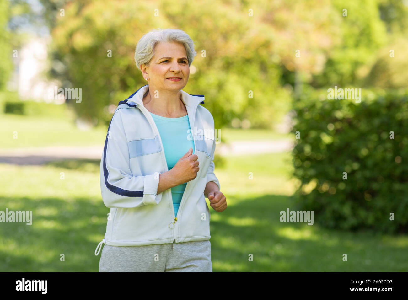 Woman mature running outdoors park hi-res stock photography and images ...