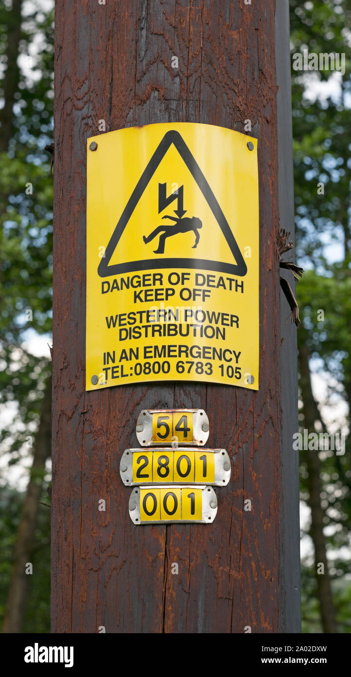 Warning sign and identification number on wooden pole supporting ...