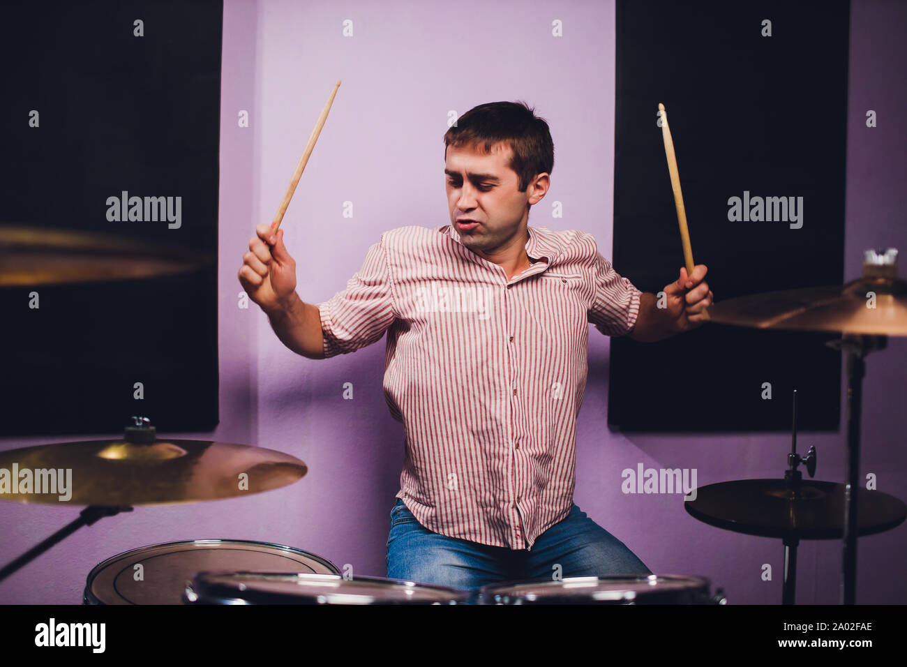 Young man behind drum-type installation in a professional recording ...