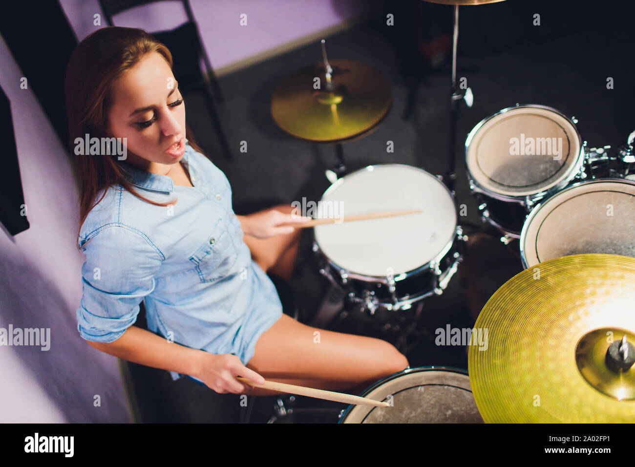 Photograph of a female drummer playing a drum set on stage Stock Photo ...