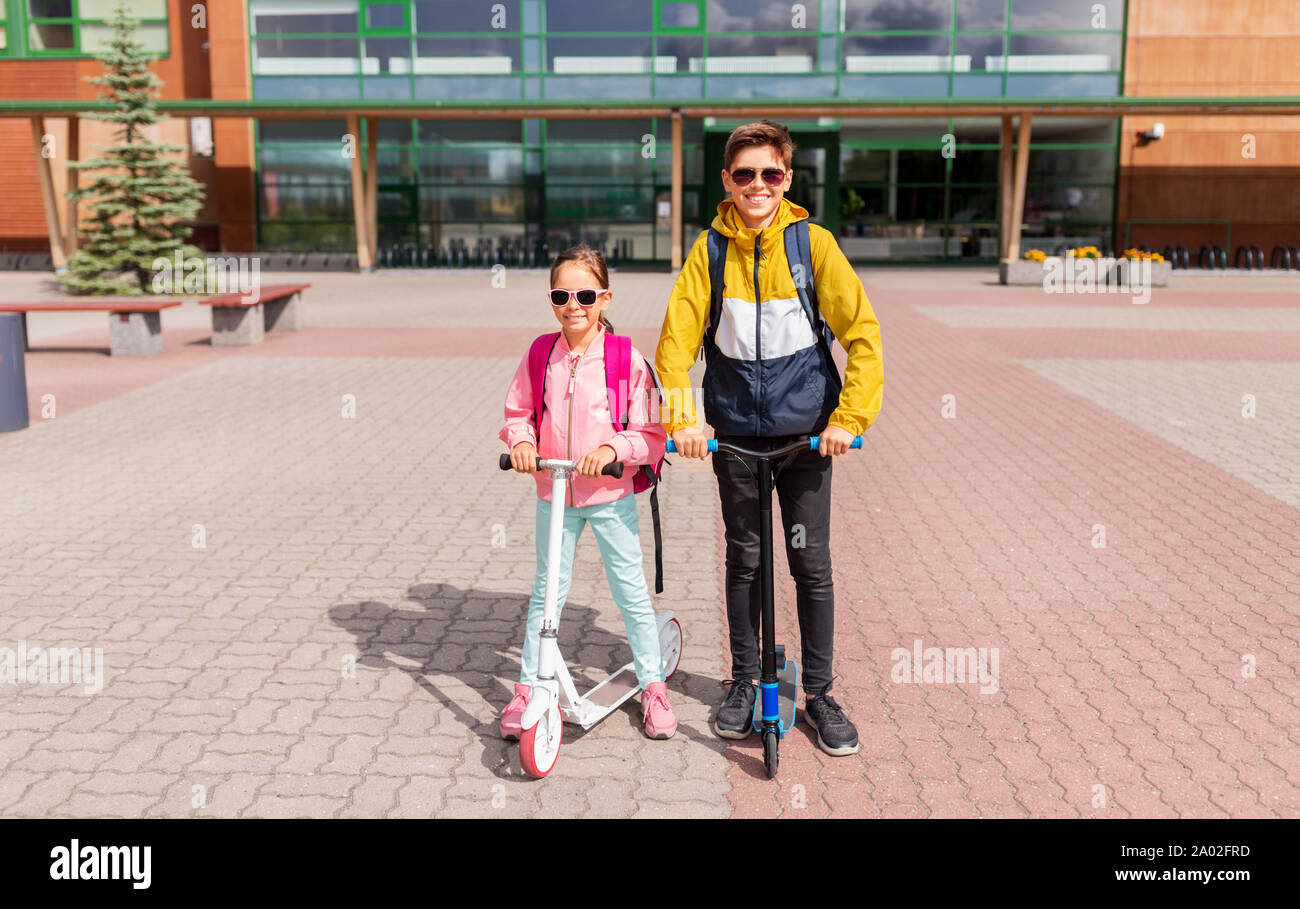 school children with backpacks riding scooters Stock Photo - Alamy