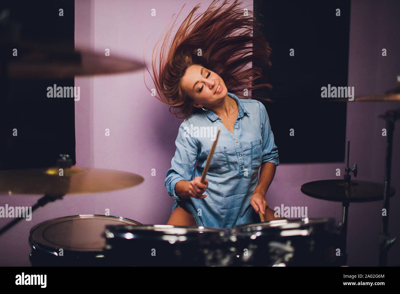 Photograph of a female drummer playing a drum set on stage Stock Photo ...