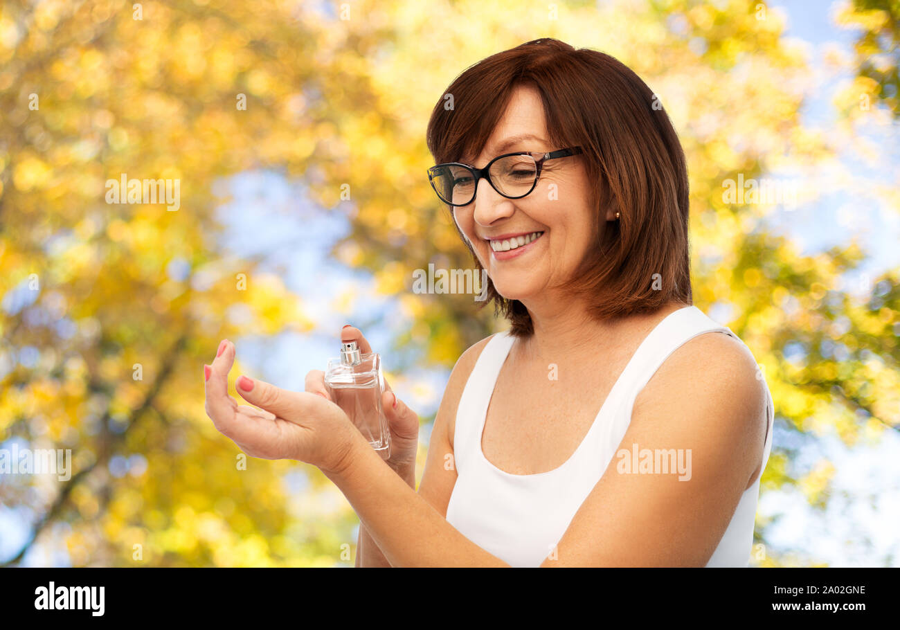 smiling senior woman spraying perfume to her wrist Stock Photo - Alamy