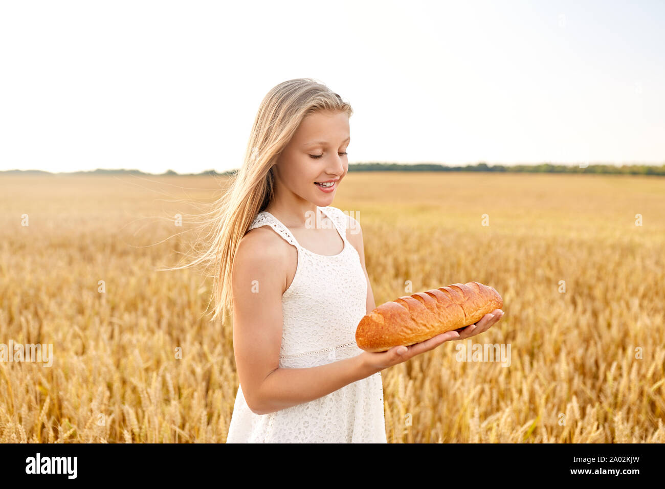 girl with loaf of white bread on cereal field Stock Photo - Alamy