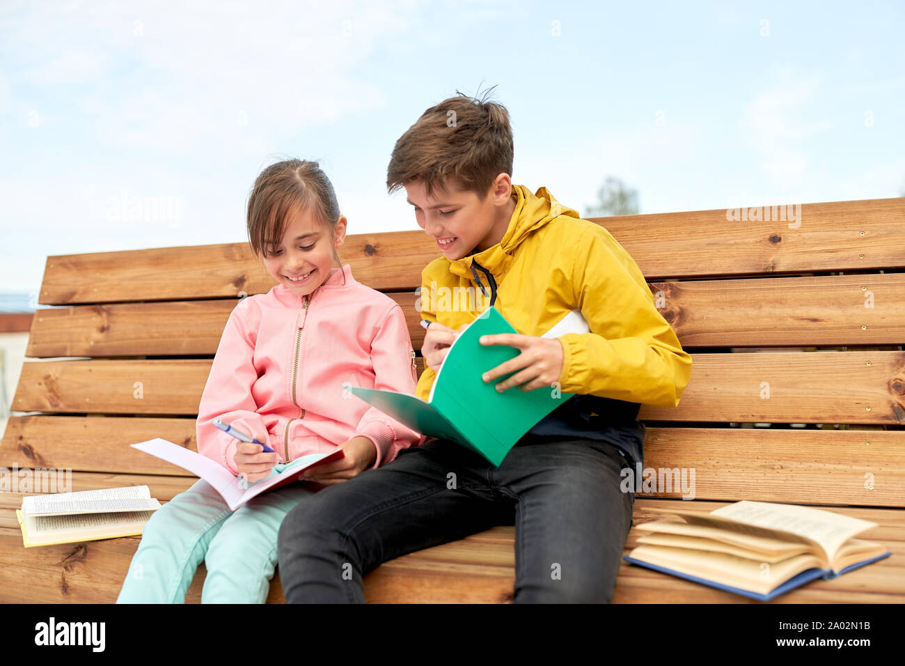 school children with notebooks sitting on bench Stock Photo - Alamy