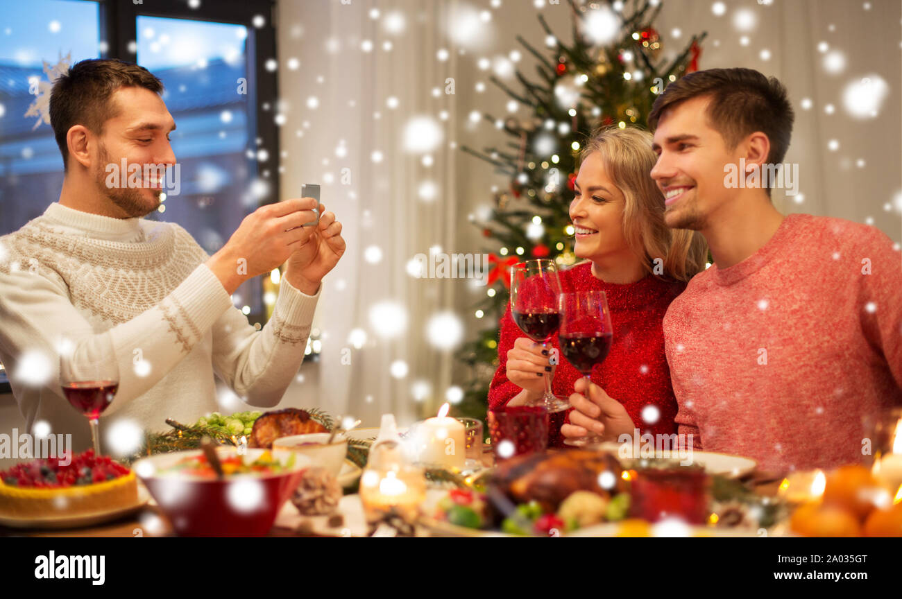 Happy friends photographing christmas hi-res stock photography and ...