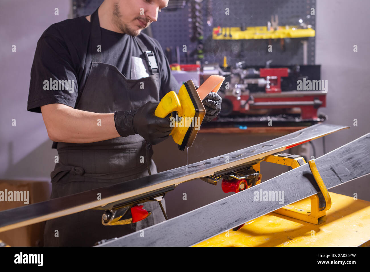 Repair, people concept - mechanic, man is rubbing a ski Stock Photo - Alamy