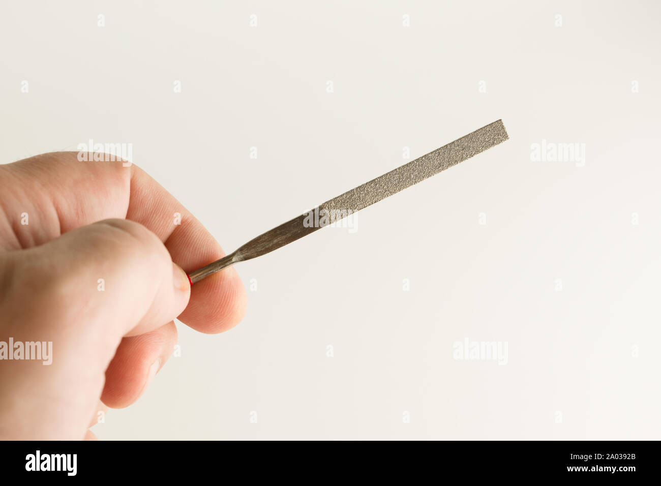 file with a long working part and a red dielectric handle isolated on a ...