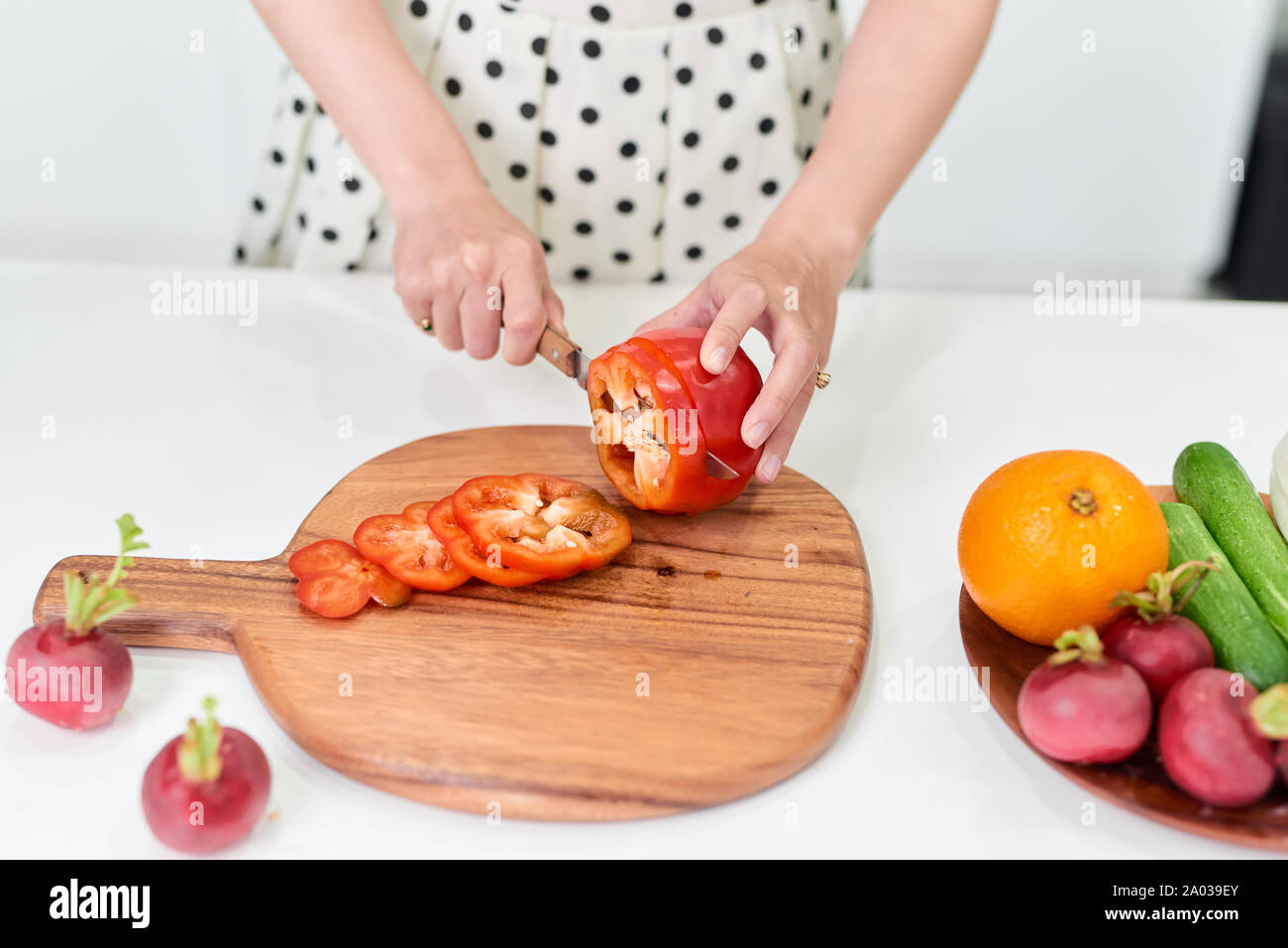 Young woman is chopping vegetables in the kitchen Stock Photo - Alamy