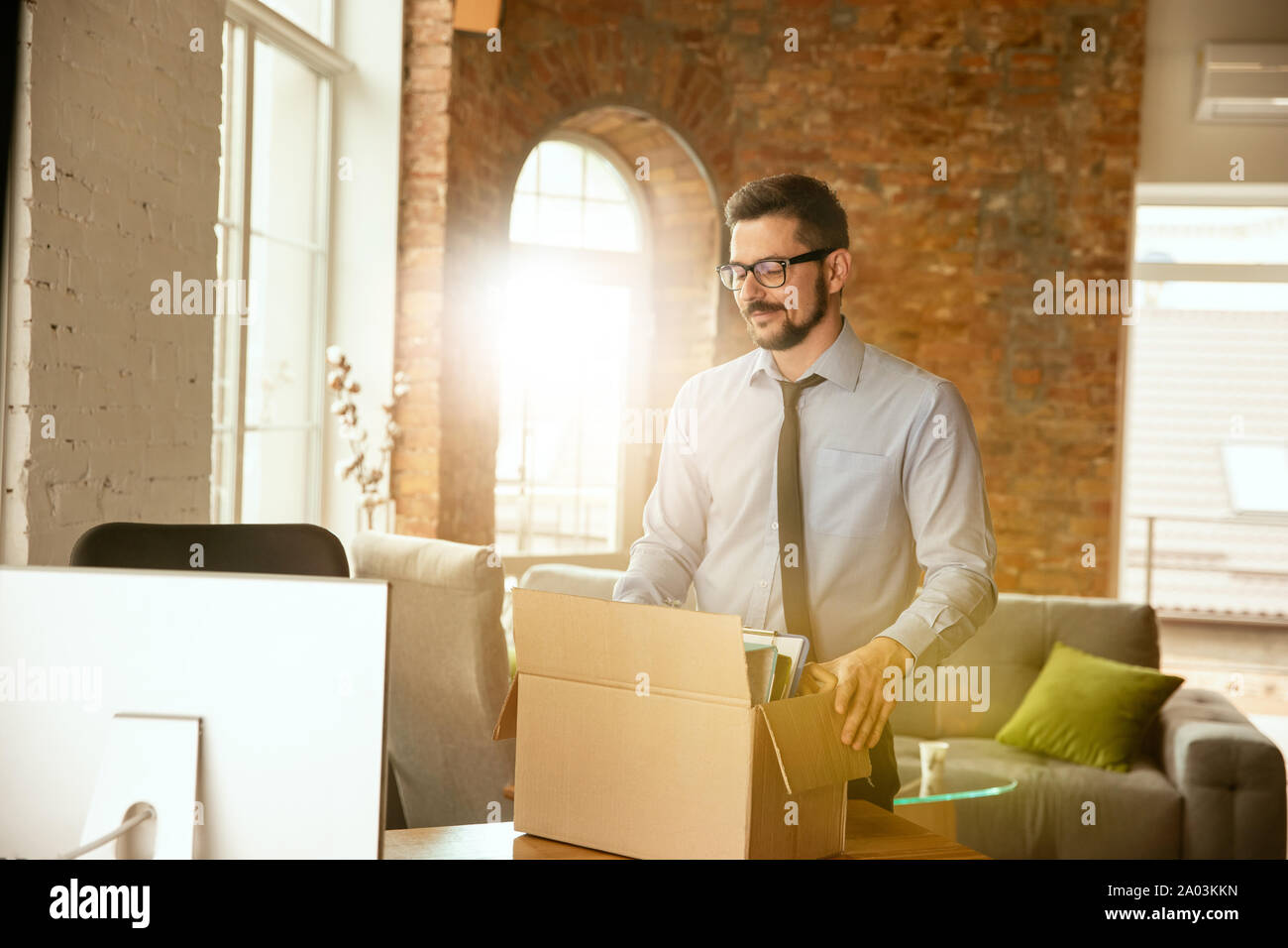 A young businessman moving in the office, getting new work place. Young ...