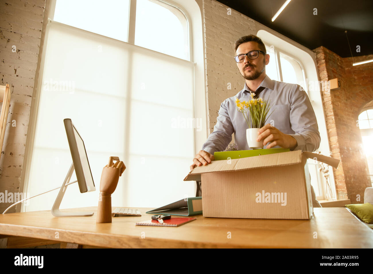A young businessman moving in the office, getting new work place. Young ...