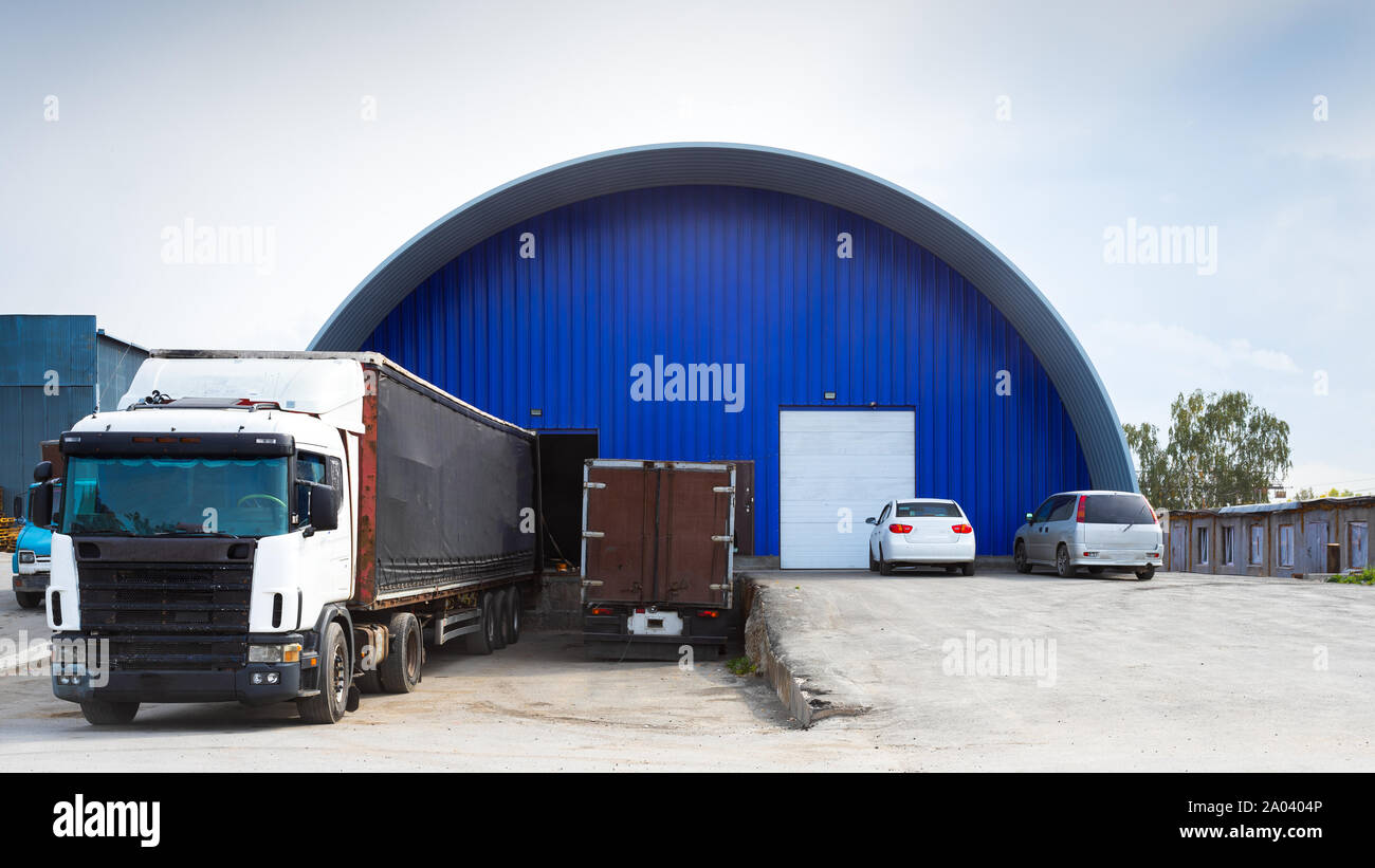 Delivering and supply concept image. Trucks loading at facility in the ...