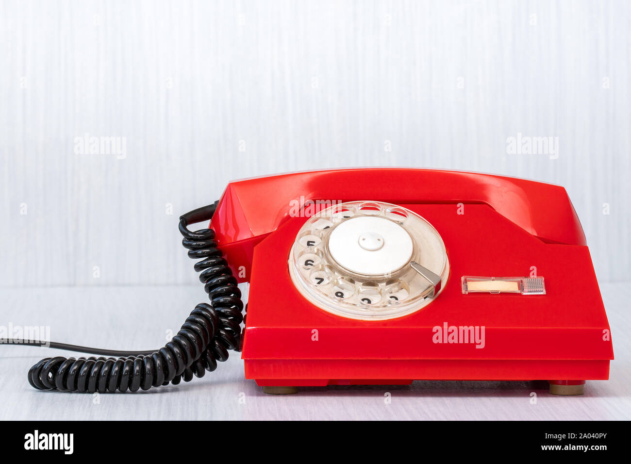 Red 80s rotary dial phone on the wooden table Stock Photo - Alamy