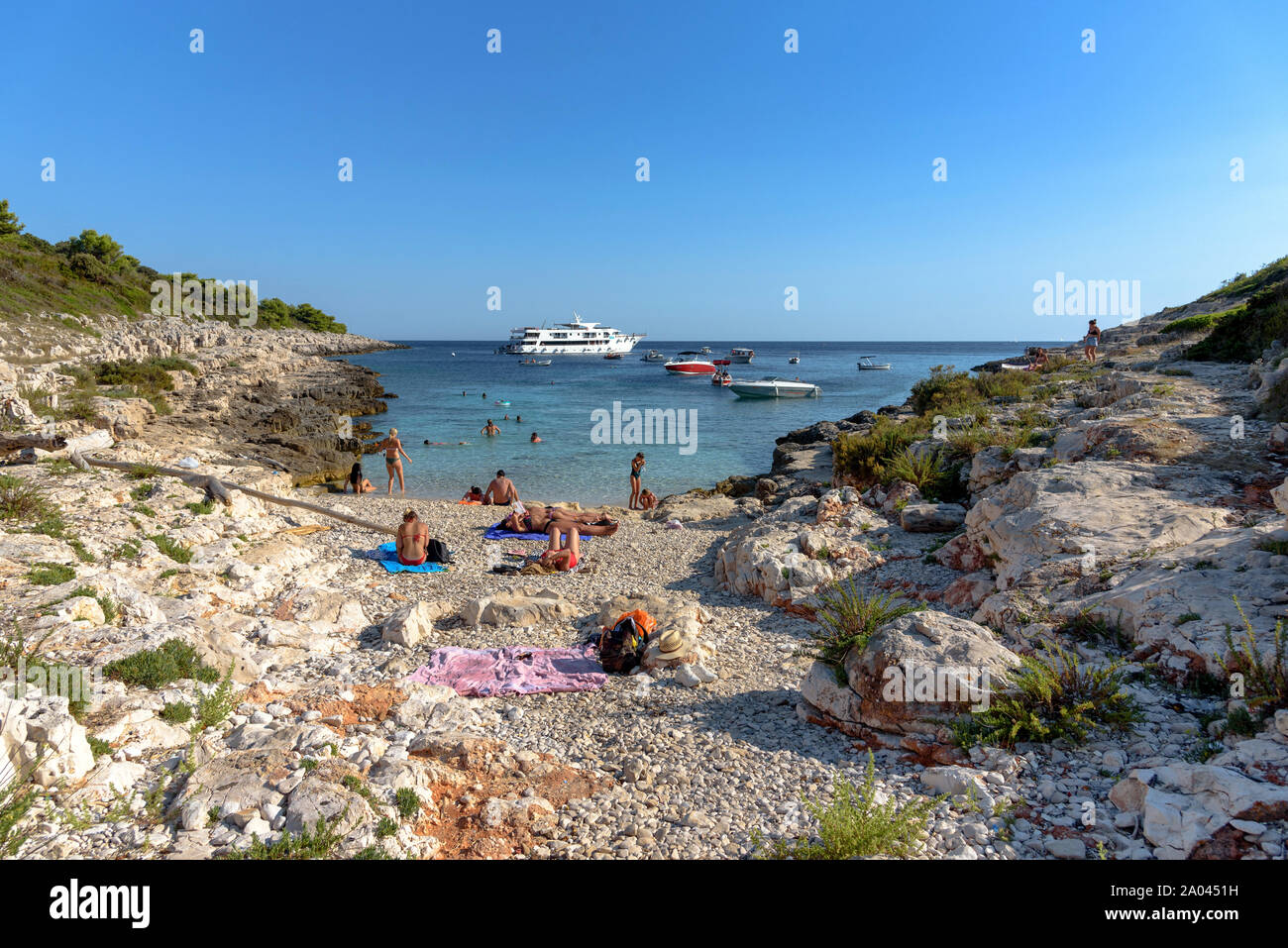 People sunbathing at Perna Beach on the Pakleni islands in Croatia ...