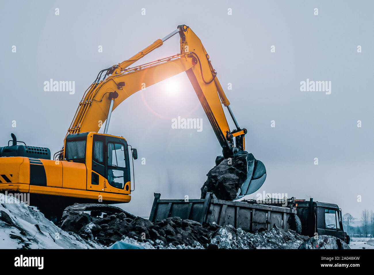 Old excavator with excavator bucket in winter. Road construction in ...