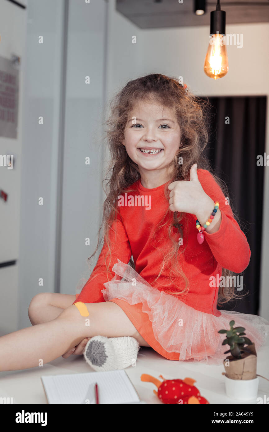 Feeling better. Charming kid expressing positivity, raising thumb up ...