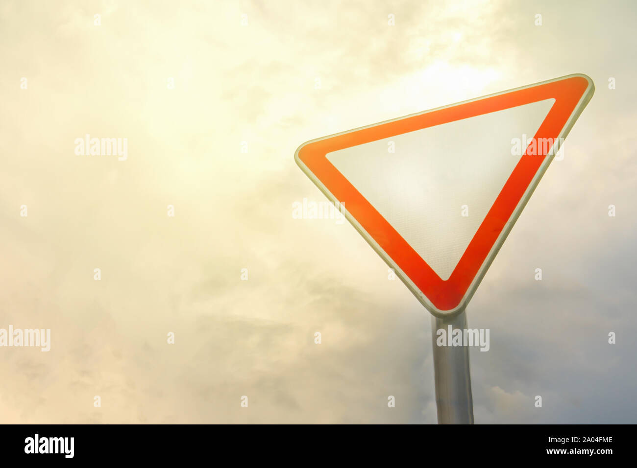 Give way traffic sign dramatically, against the sky and clouds Stock ...