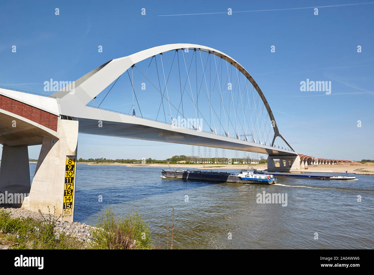 River barge navigating under a bridge named De Oversteek which spans ...