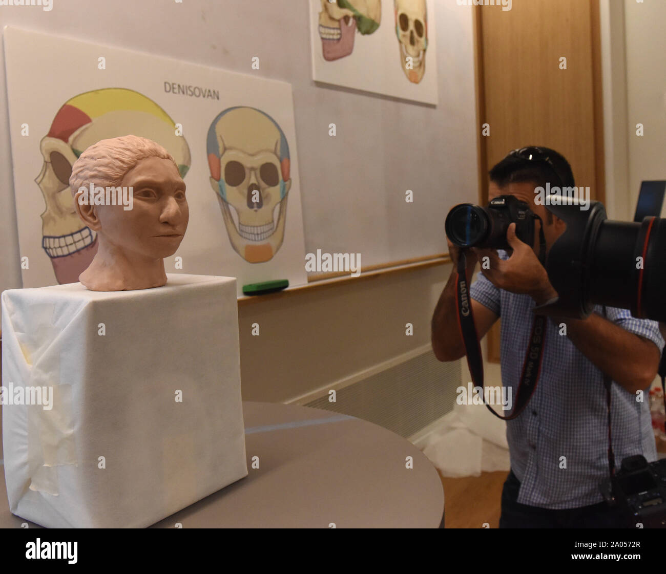 Journalists photograph a close-up of the 3D printed reconstruction of a ...