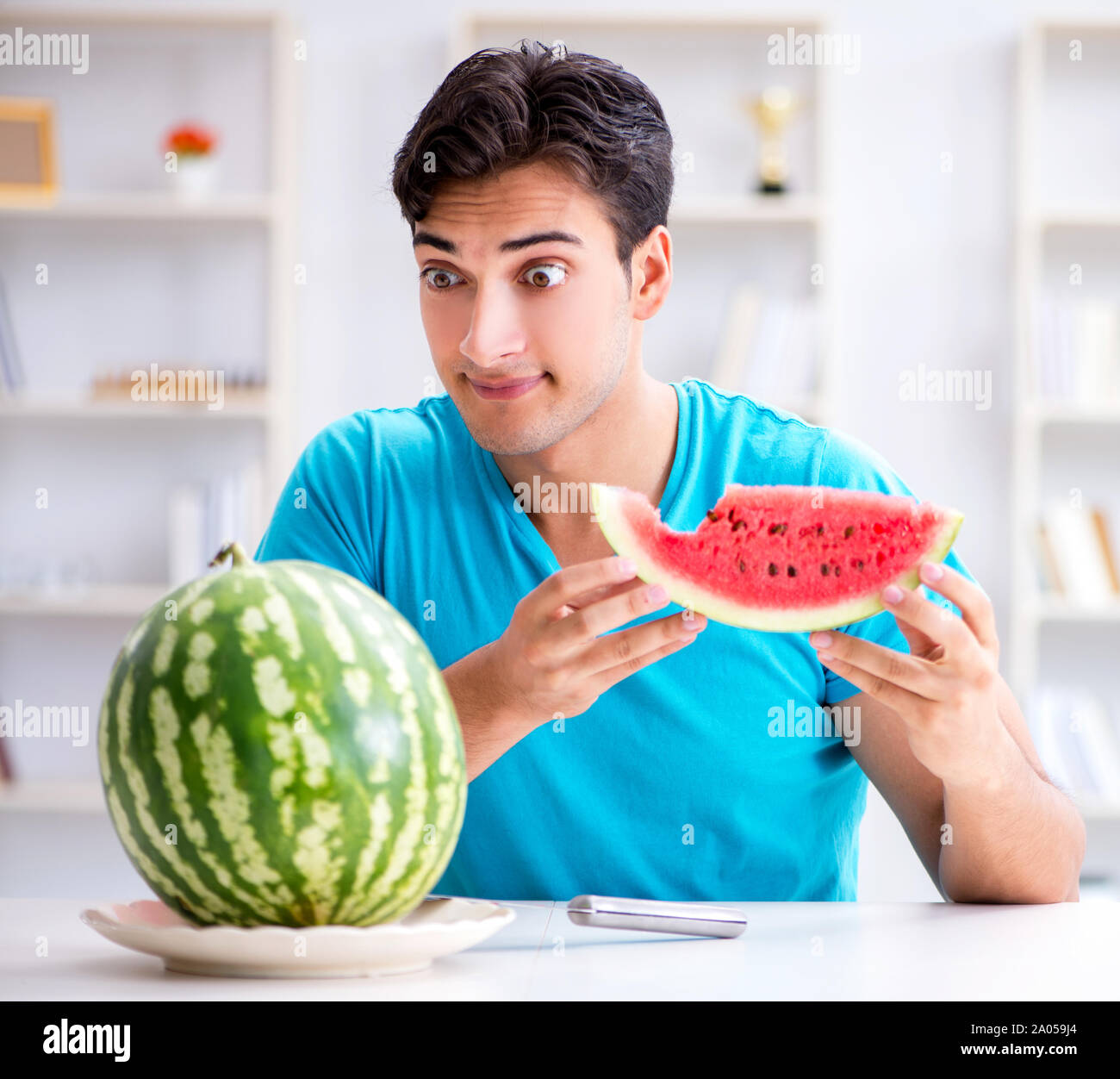 The man eating watermelon at home Stock Photo - Alamy