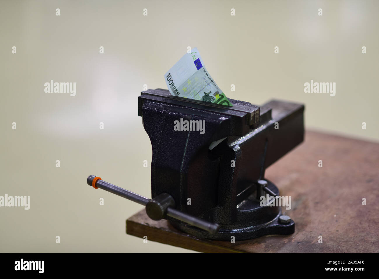Bank note of hundred euro squeezed in vise. Bank note fixed by vise ...
