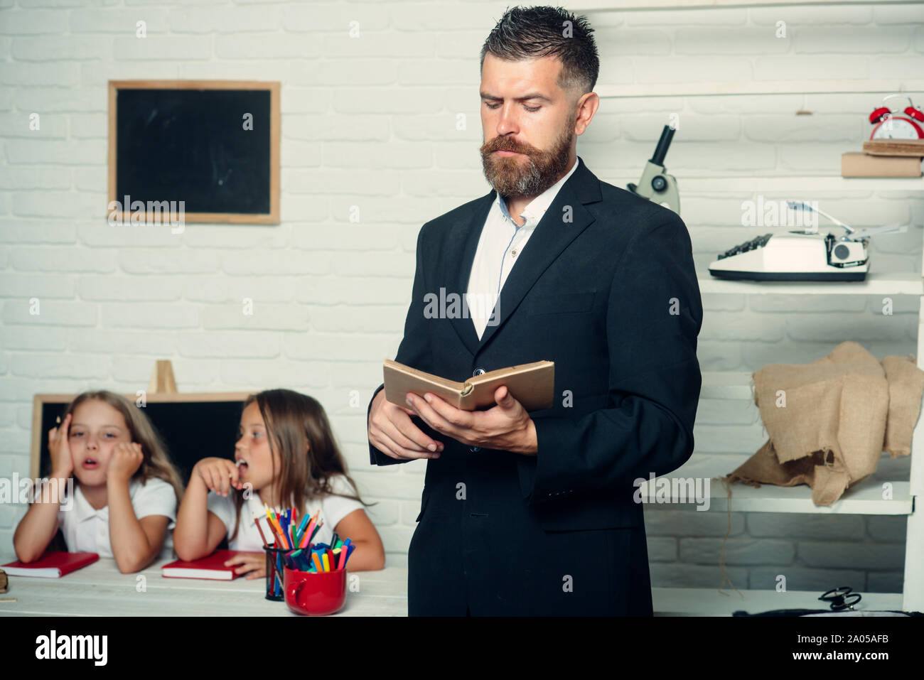 Man teacher read story to girls eating apple. teacher man and children ...