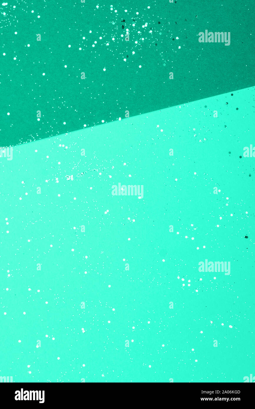 Glitter scattered on the trendy mint green card background, top view ...