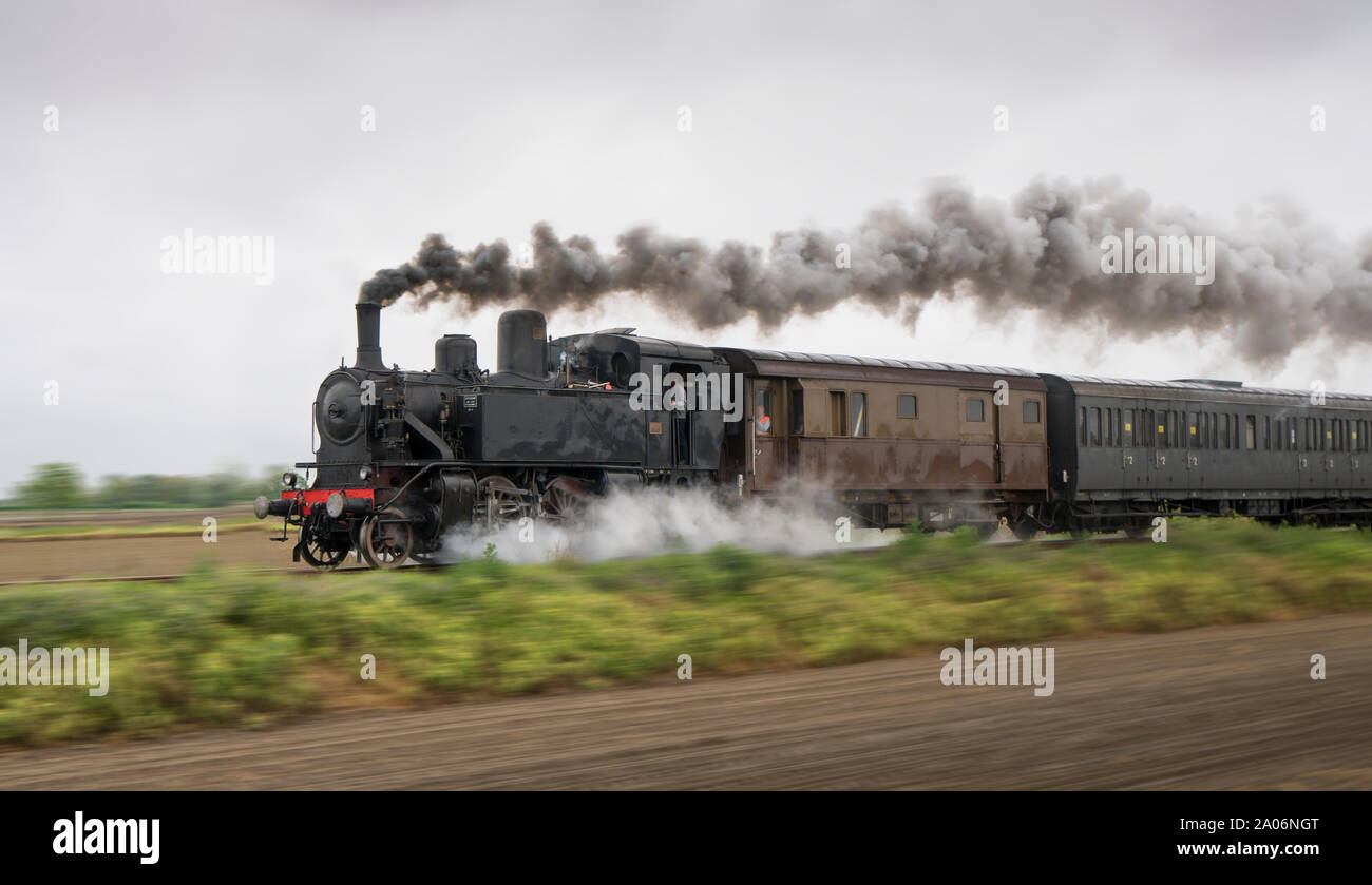 Vintage steam train with ancient locomotive and old carriages runs on ...