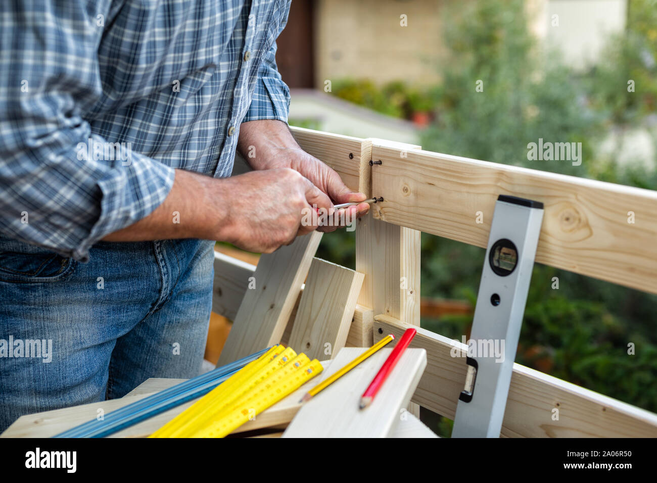 Adult carpenter craftsman with screwdriver screw the screw to fix the ...
