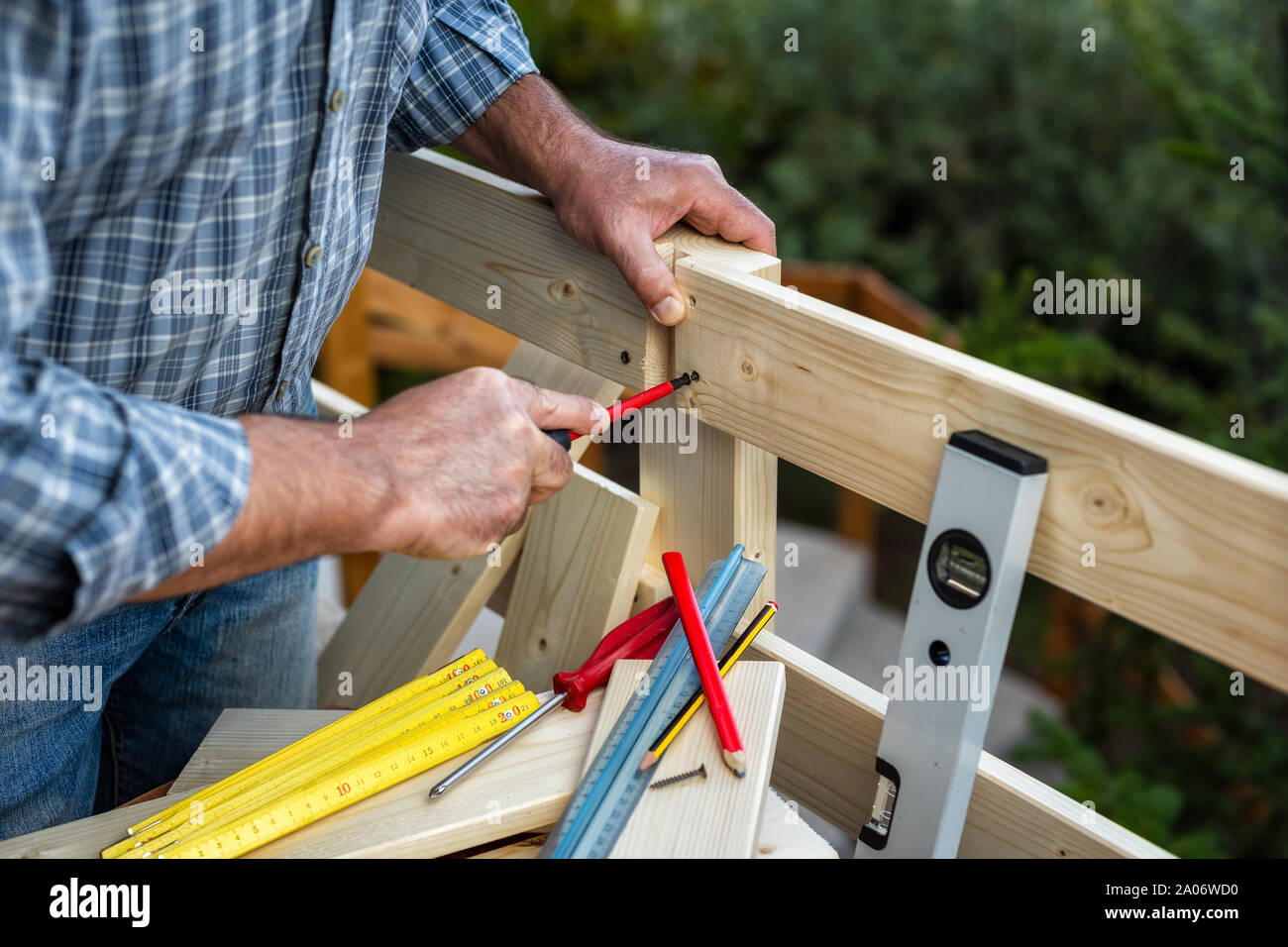 Adult carpenter craftsman with screwdriver screw the screw to fix the ...