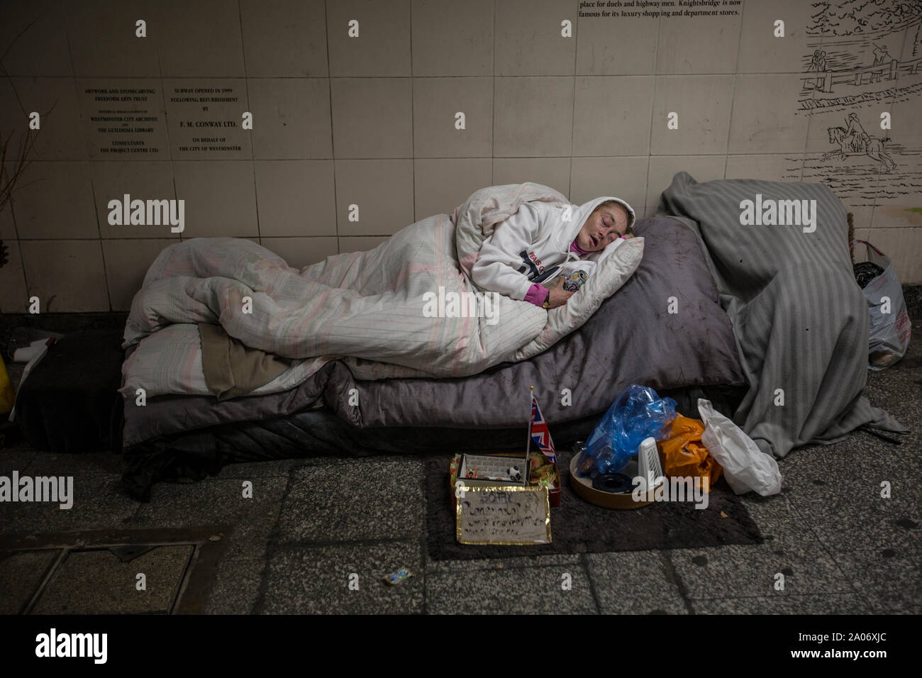 A homeless woman sleeps in a subway leading to Hyde Park Corner ...