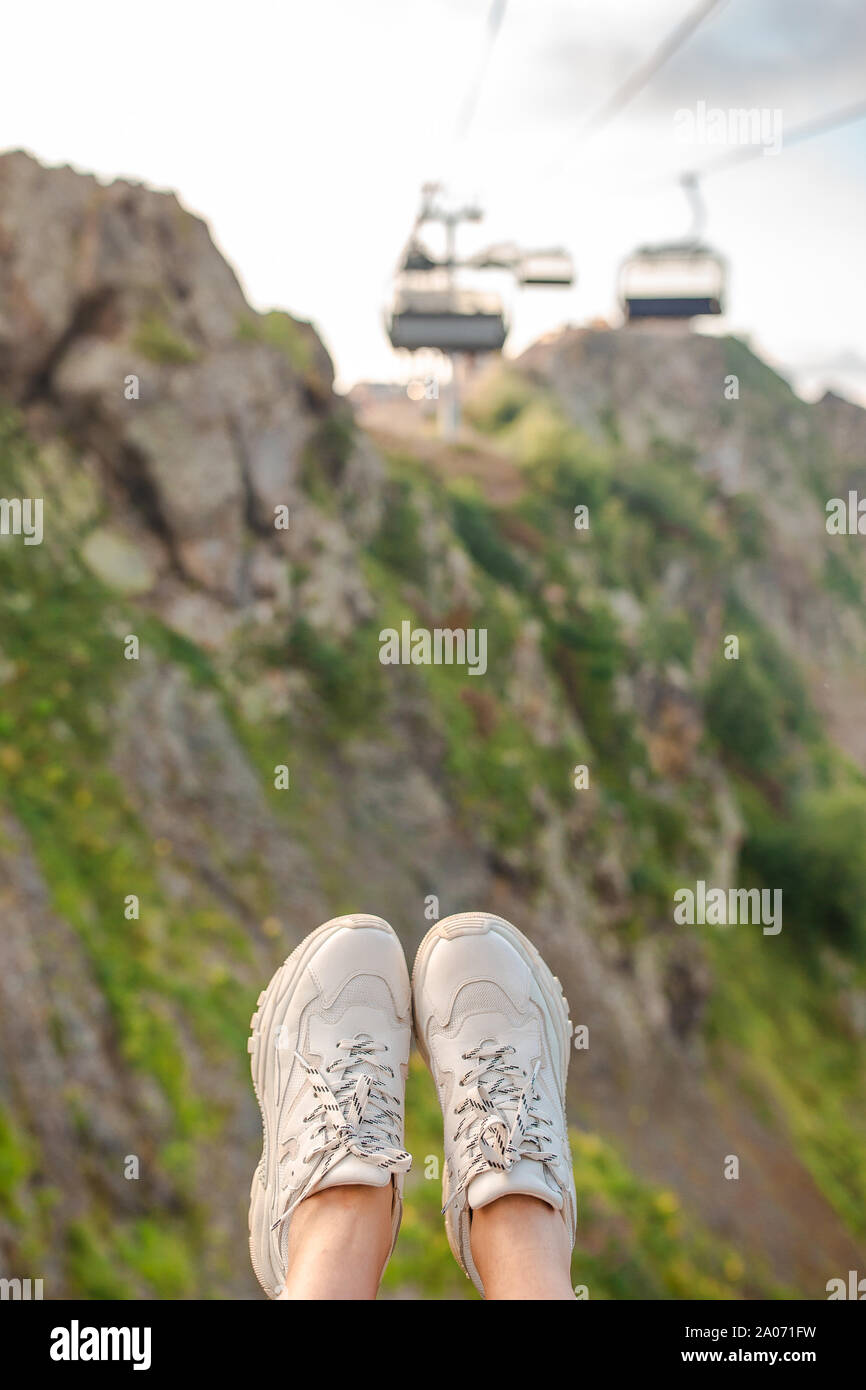 Close-up of female legs in sneakers in mountains on the cable car Stock ...