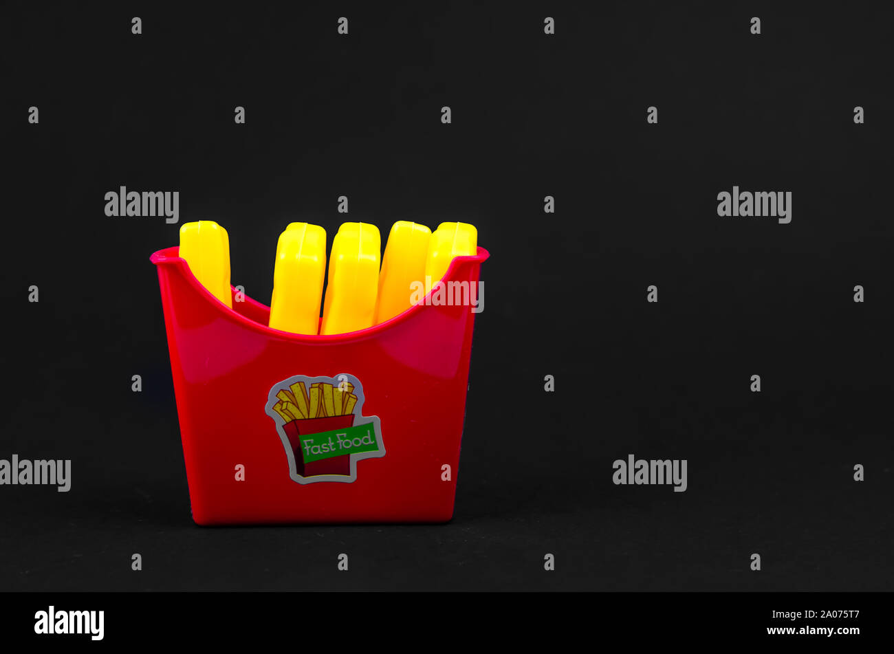 fast food. plastic french fries on a black background. copy space ...