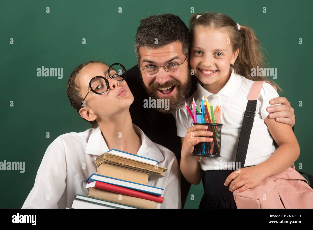 A girl carries a heavy pile of books. teacher and students with heavy ...