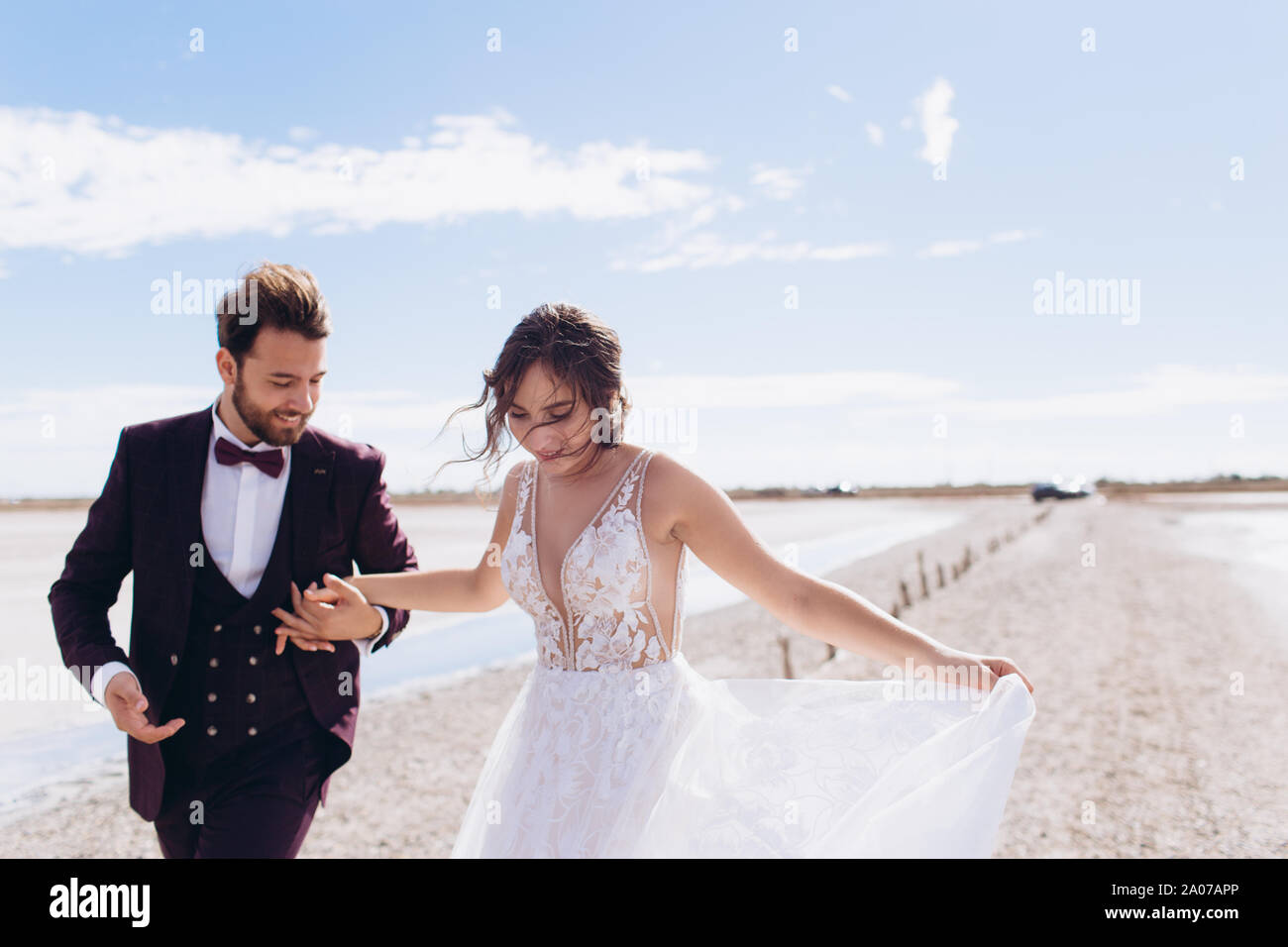 Happy bride and groom on a wedding day run and smile Stock Photo - Alamy