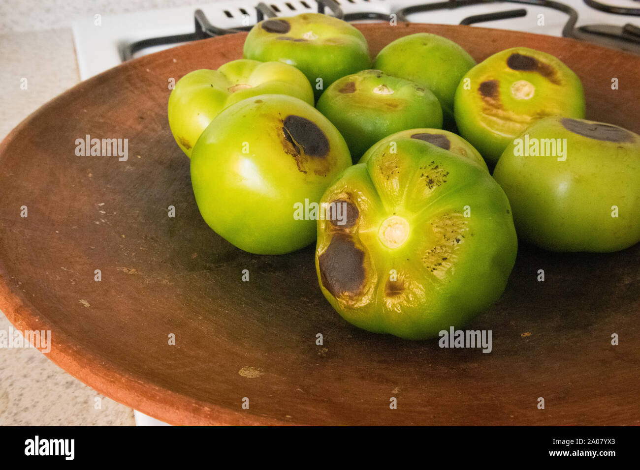 Roasting Tomatillos on Traditional Clay Comal Stock Photo - Alamy