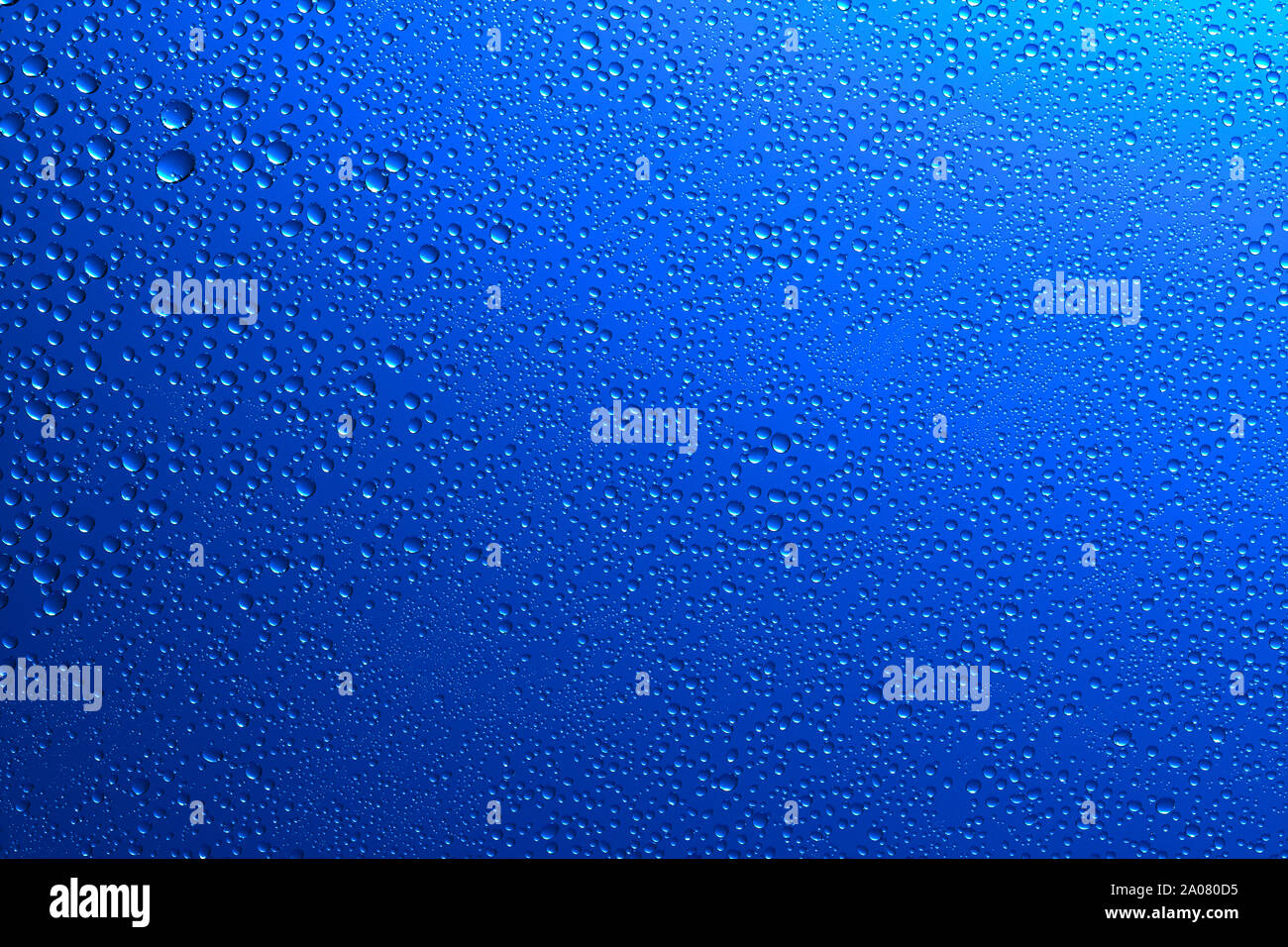 Sparkling water droplets on a translucent blue glass background with ...