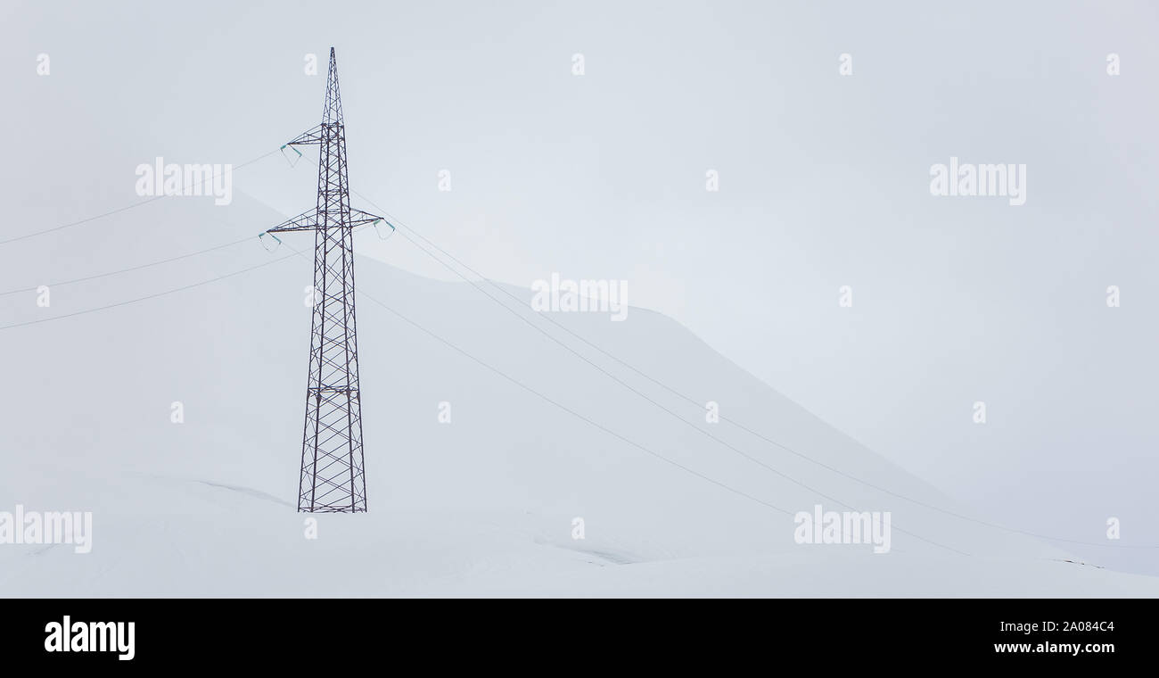 A picture of a transmission tower in a completely white snow-covered ...