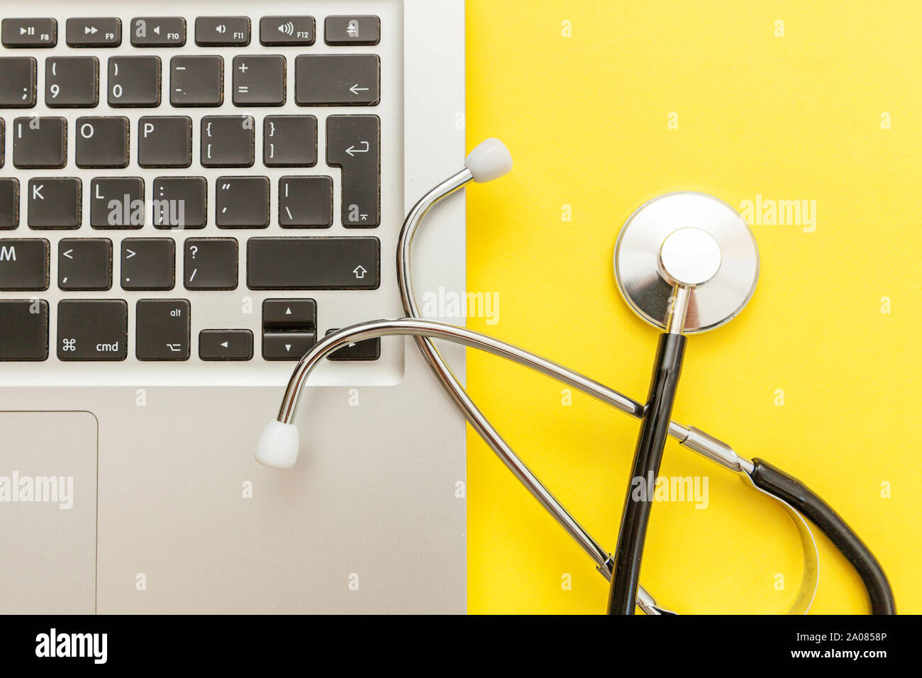Stethoscope keyboard laptop computer isolated on yellow background ...