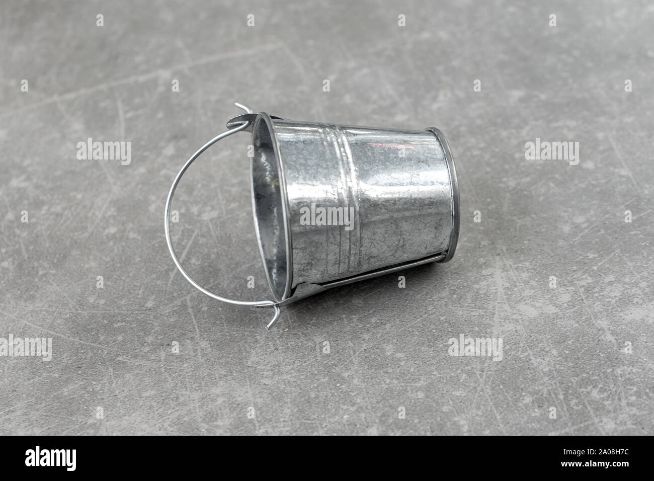 Empty small metal bucket isolated on a concrete background. Copy space ...
