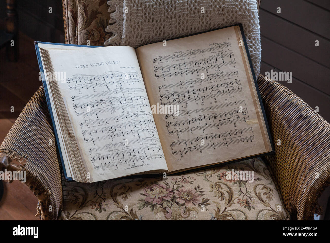 Antique song and music book open on an old chair at the heritage ...
