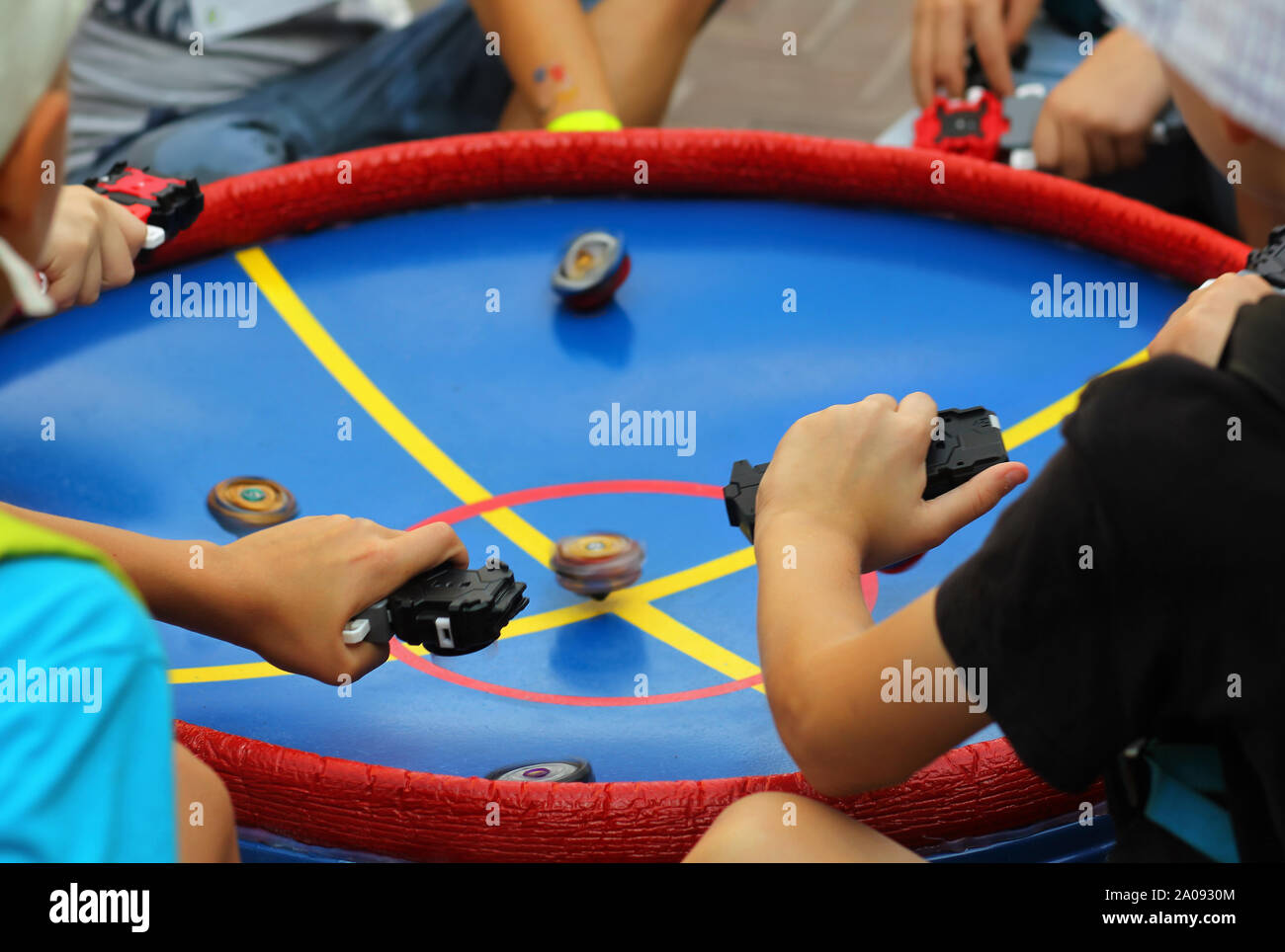Boys playing popular game beyblade with special spinning tops at the ...