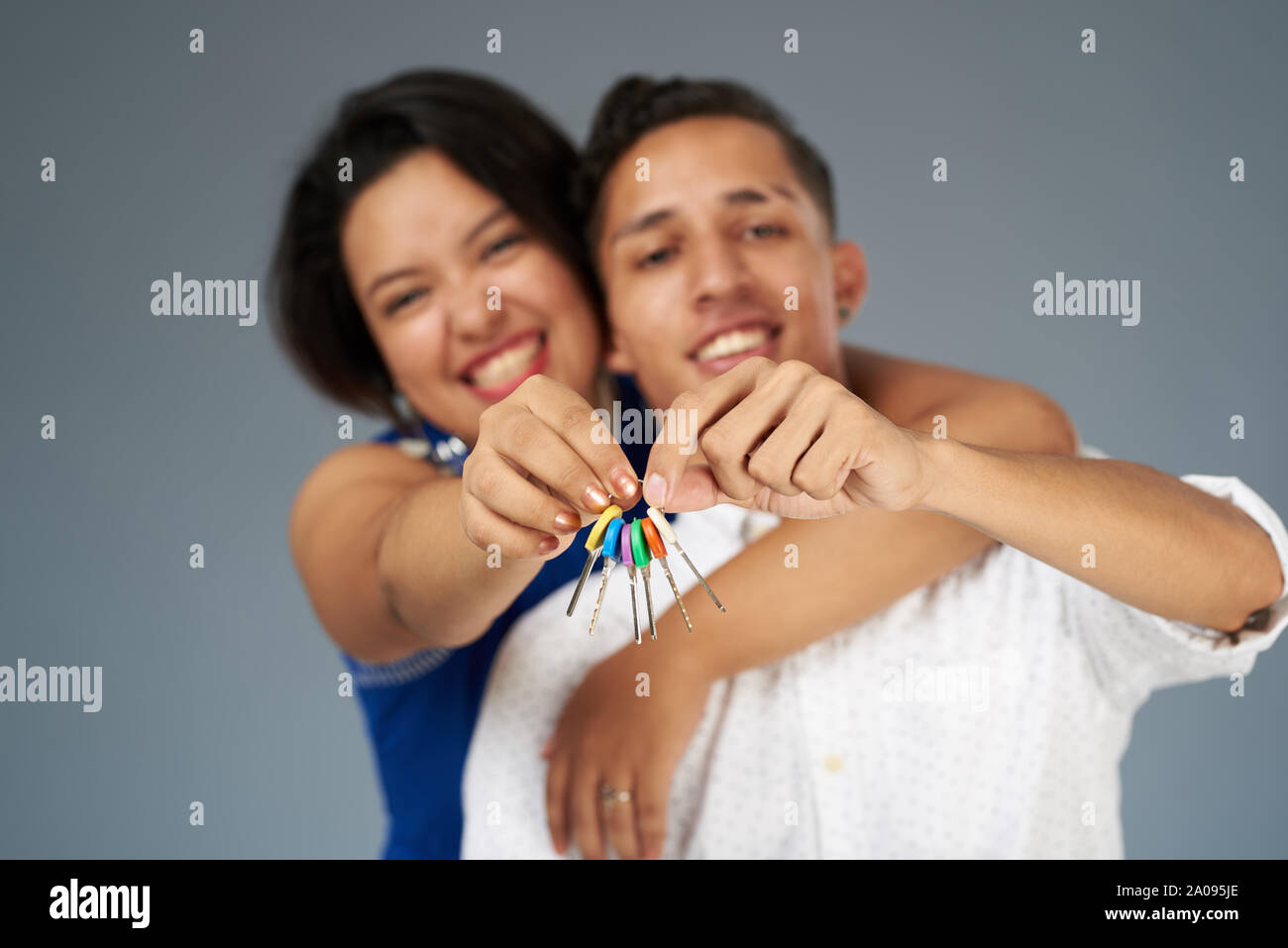 Colorful house key in young couple hands with blurred background Stock ...