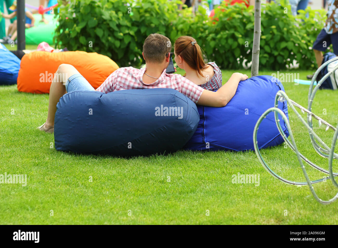 Cuddling couple on bean bags enjoy picnic in the park Stock Photo - Alamy