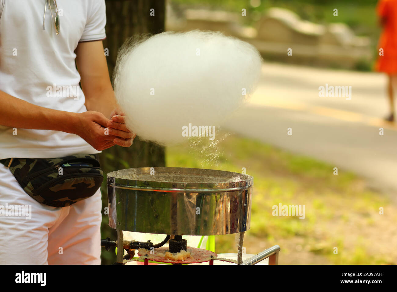 Closeup of salesman rolling cotton candy in the floss machine. Man at ...