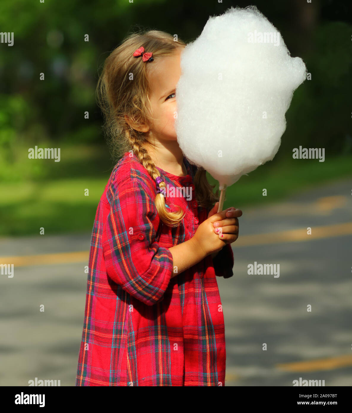Happy toddler girl eating cotton candy Stock Photo - Alamy