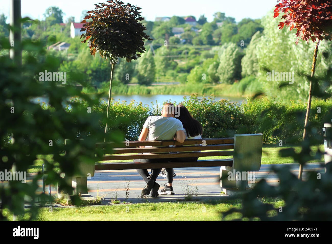 Cuddling couple on the bench in the summer park Stock Photo - Alamy